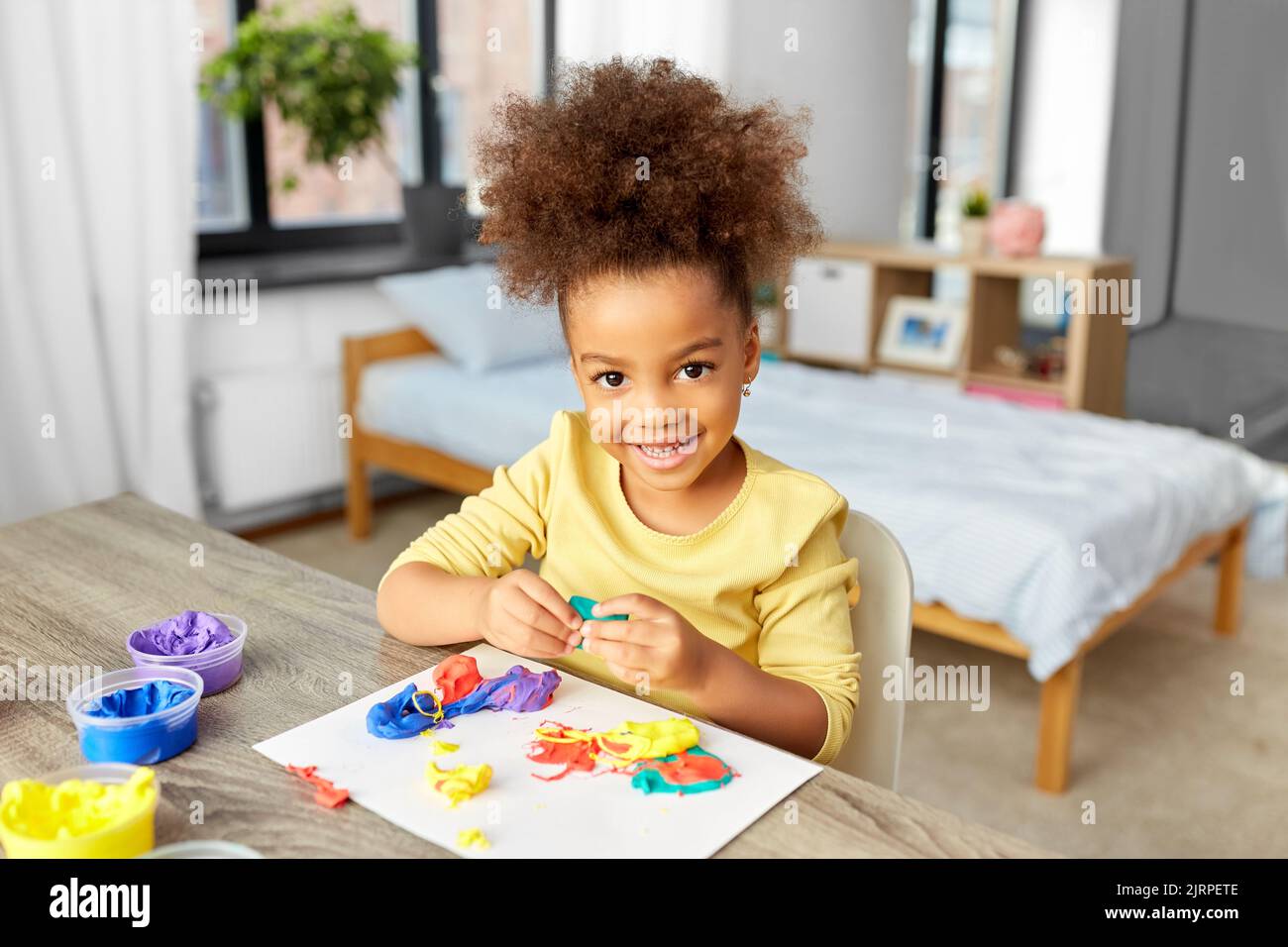 little girl with modeling clay playing at home Stock Photo - Alamy