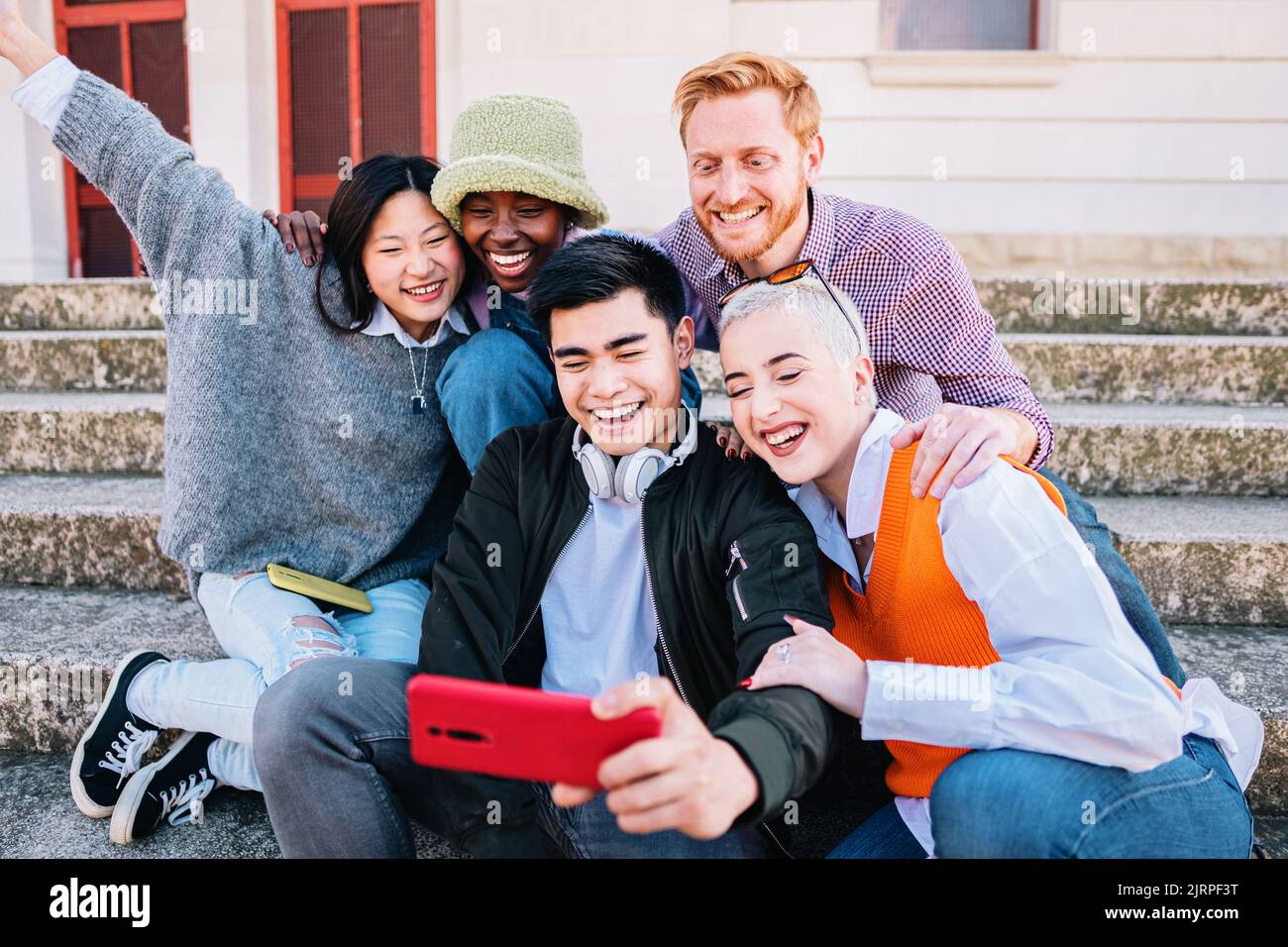 Five diverse friends taking a picture with a smartphone smiling and ...