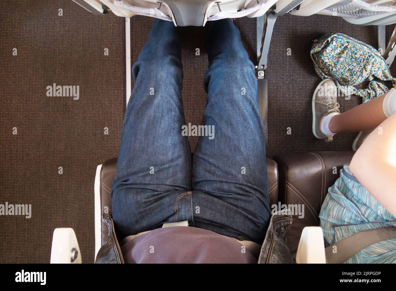 Passenger sitting in seat on an airplane / aeroplane / plane showing ...