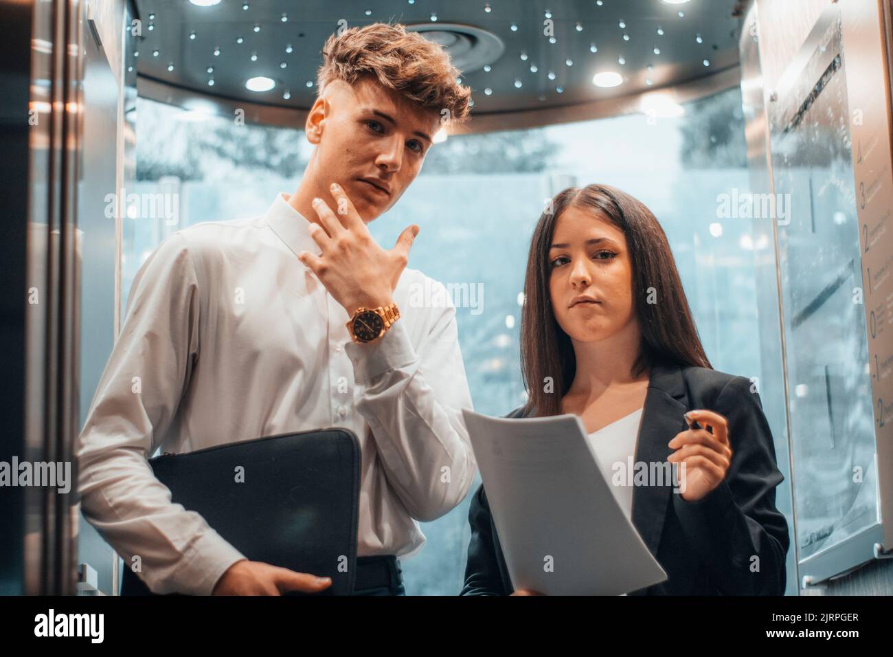 A young businessman and businesswoman in an elevator Stock Photo - Alamy