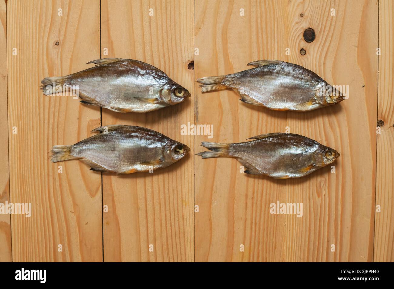 Dried salted fish on a wooden background. The fish is completely salted ...