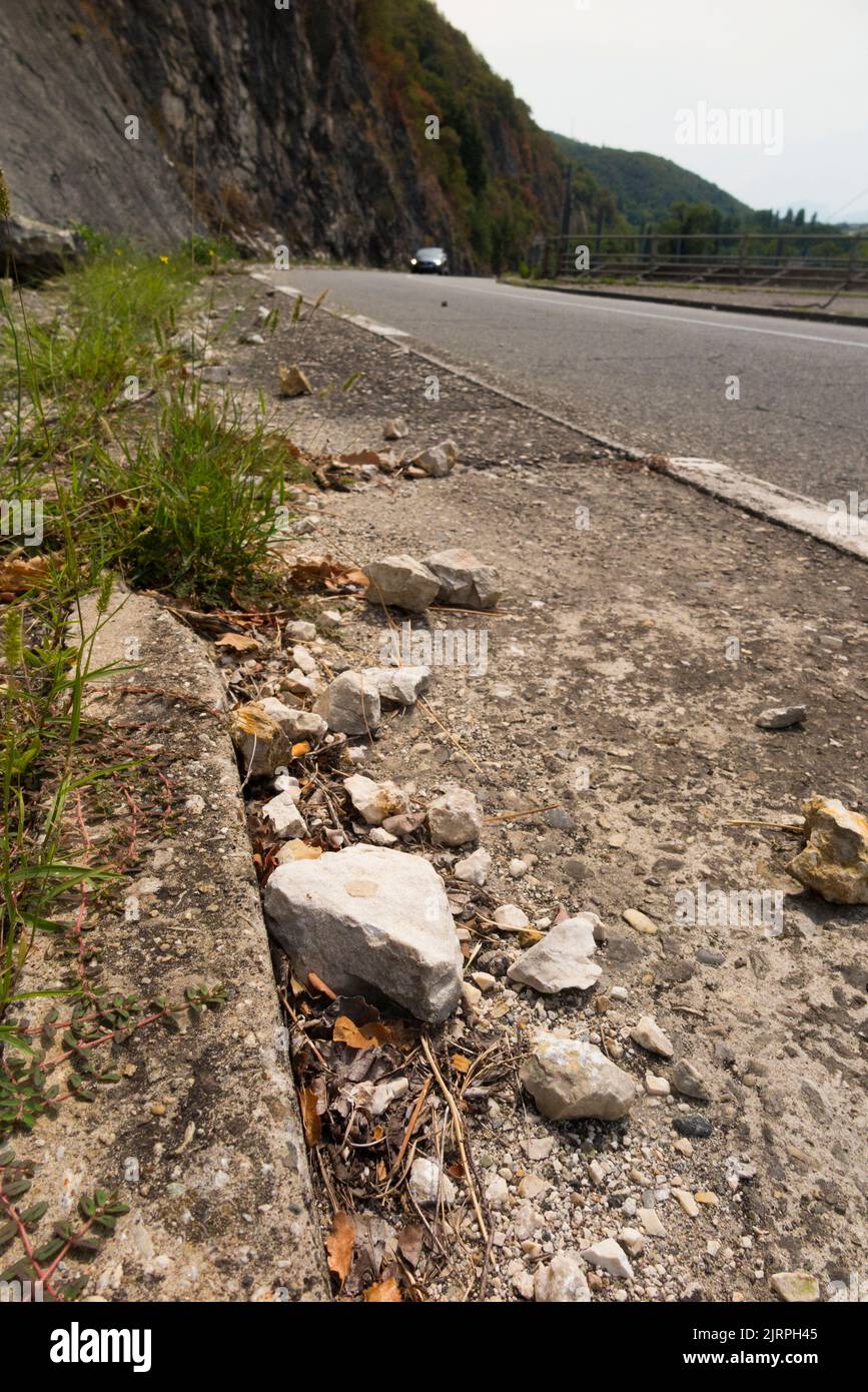 Fallen rock / cliff rocks on the road cause a hazard to car, drivers ...