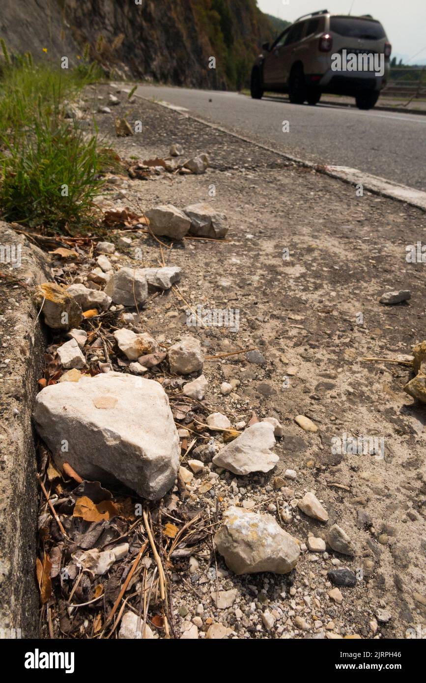 Fallen rock / cliff rocks on the road cause a hazard to car, drivers ...