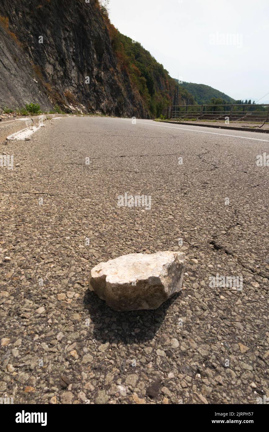 Fallen rock / cliff rocks on the road cause a hazard to car, drivers ...