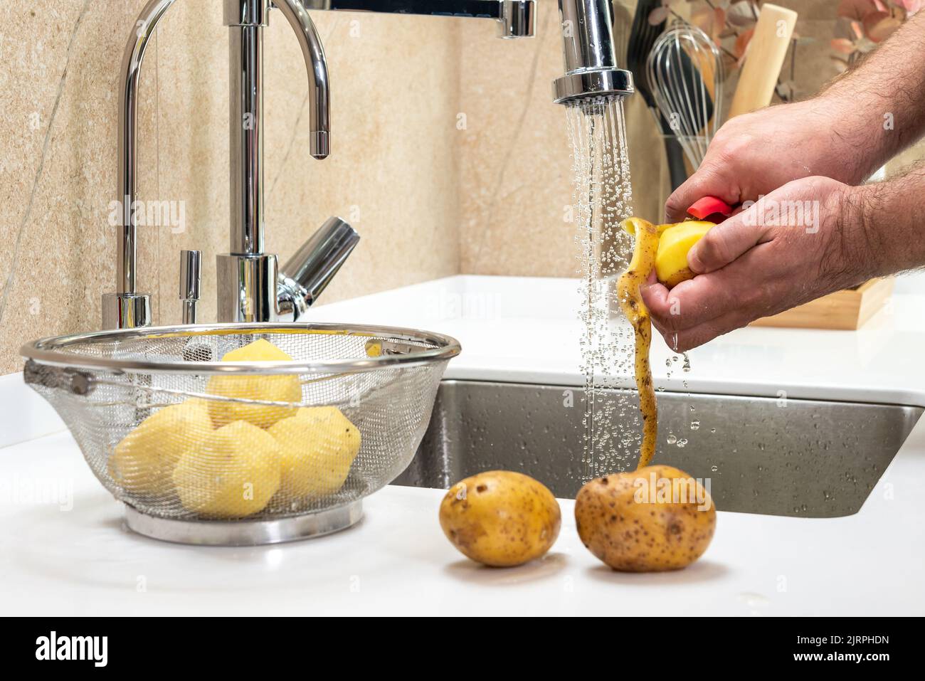 Cleaning and drying fresh potatoes in the kitchen in the sink Stock ...