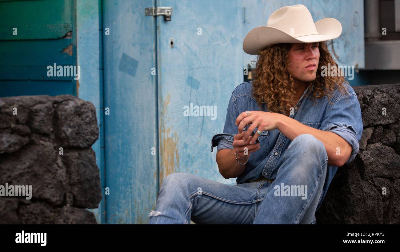 Cowboy in blue denim with stetson hat Stock Photo - Alamy