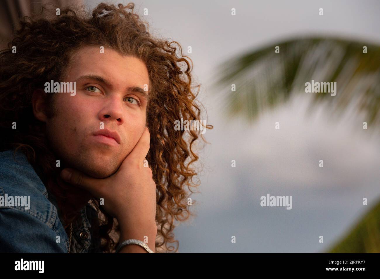 Moody male with flowing hair in sunset tropics Stock Photo - Alamy