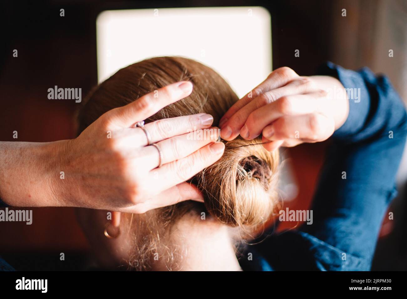 Close up of mature woman making hair bun at home Stock Photo - Alamy