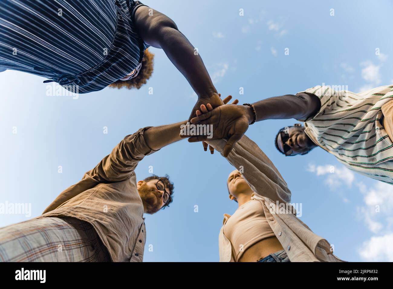 Multi race hands on top of each other hi-res stock photography and ...