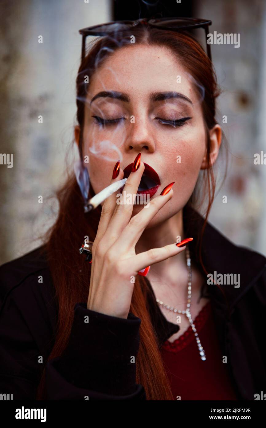 Close-up of a red-haired girl smoking a joint Stock Photo - Alamy
