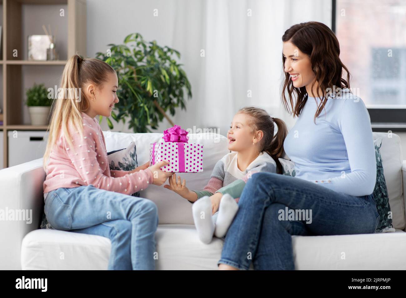 girl giving present to younger sister at home Stock Photo - Alamy