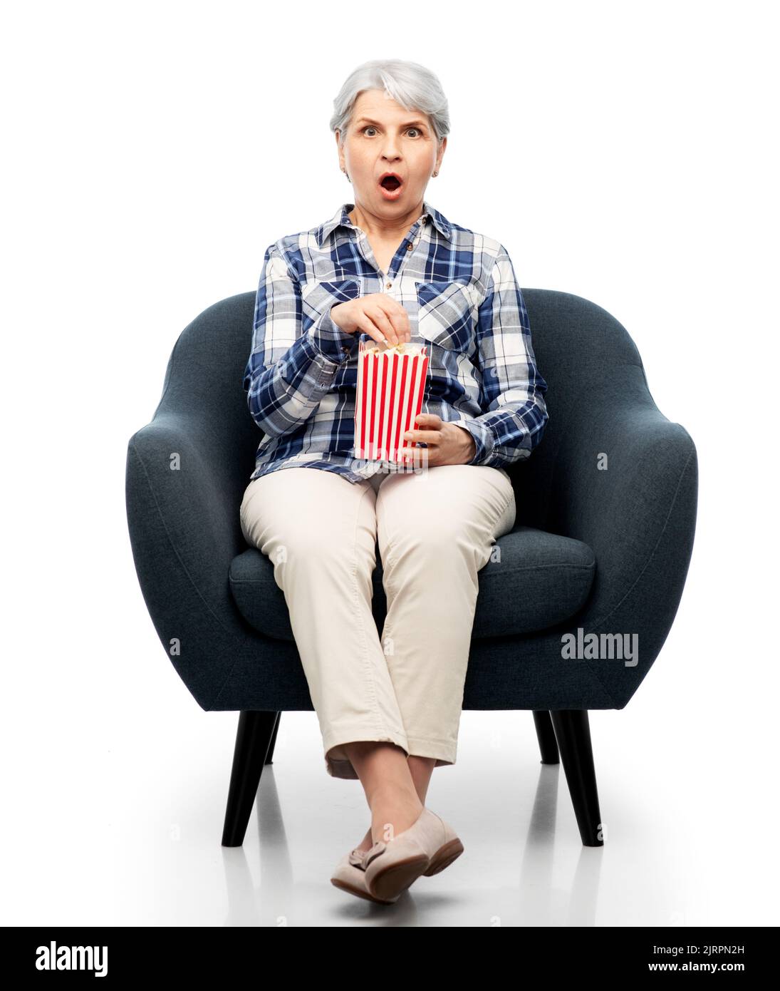 senior woman eating popcorn sitting in armchair Stock Photo - Alamy