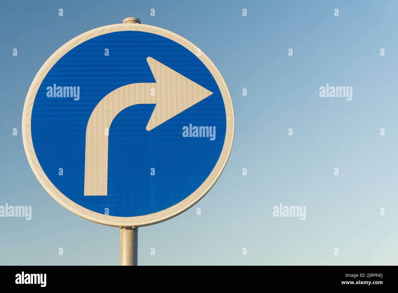 Road sign blue right turn signal on sky background Stock Photo - Alamy