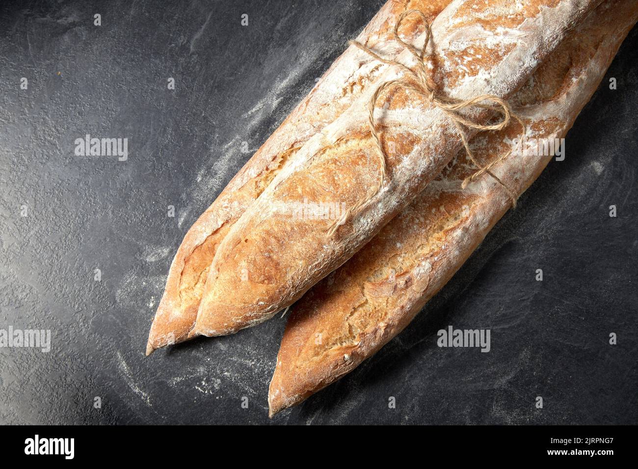 pile of baguette bread loaves tied with rope Stock Photo - Alamy