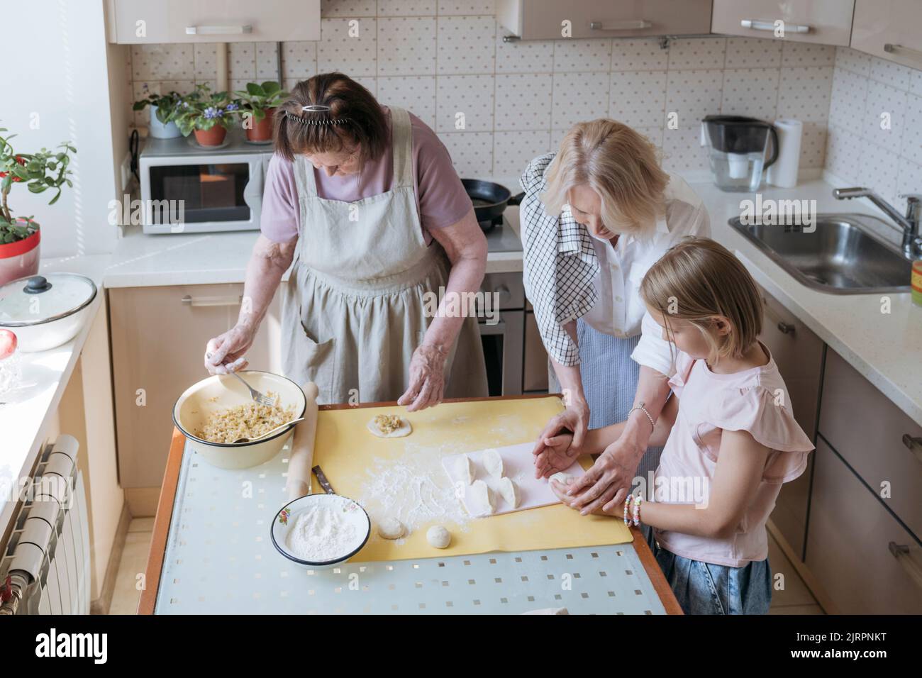 Three women in the kitchen are cooking pies together Stock Photo - Alamy