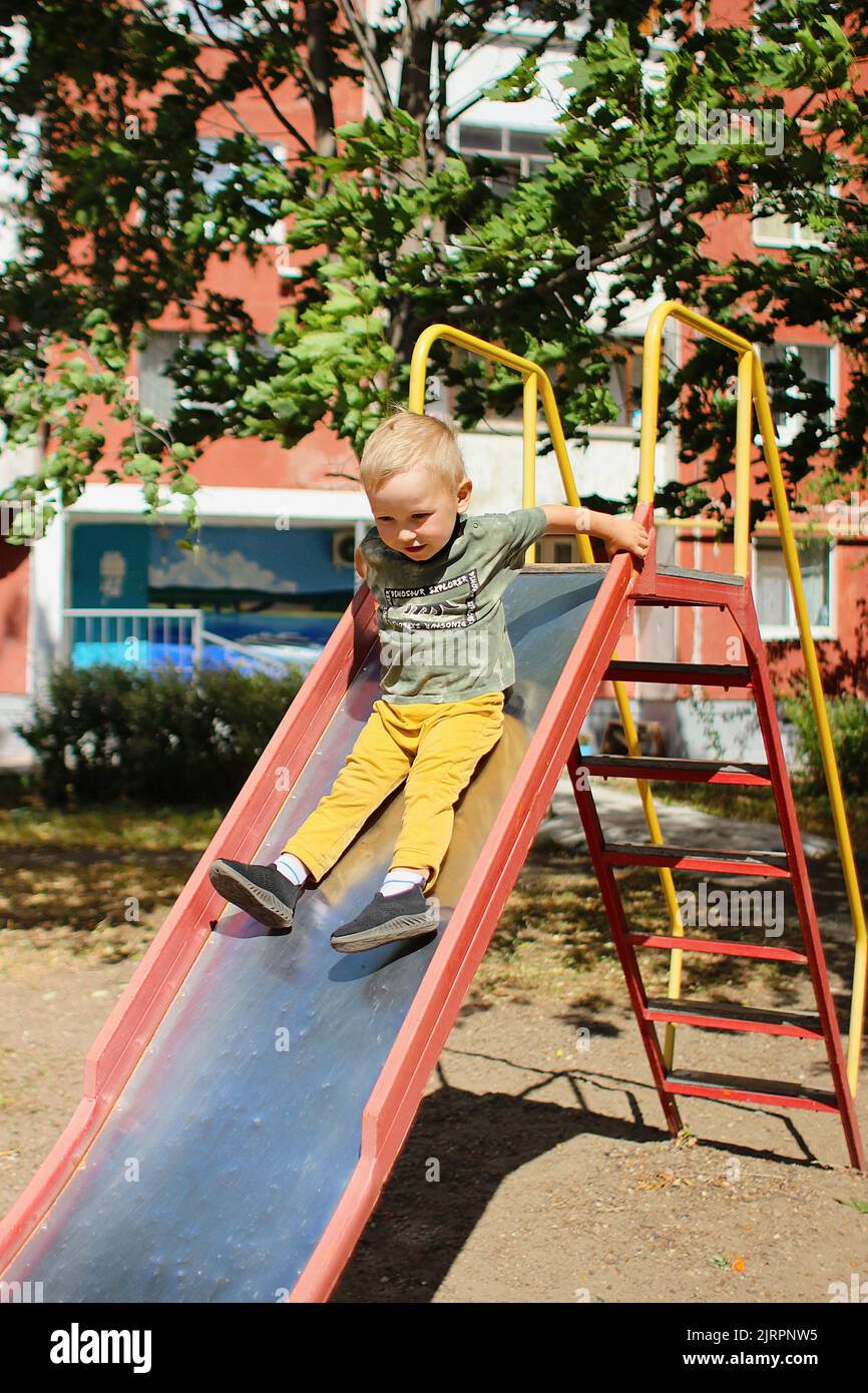 Boy on slide at playground Stock Photo - Alamy
