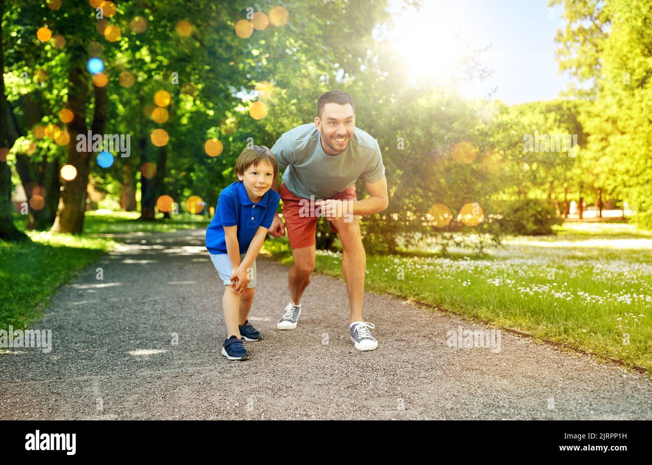 happy father and son compete in running at park Stock Photo - Alamy