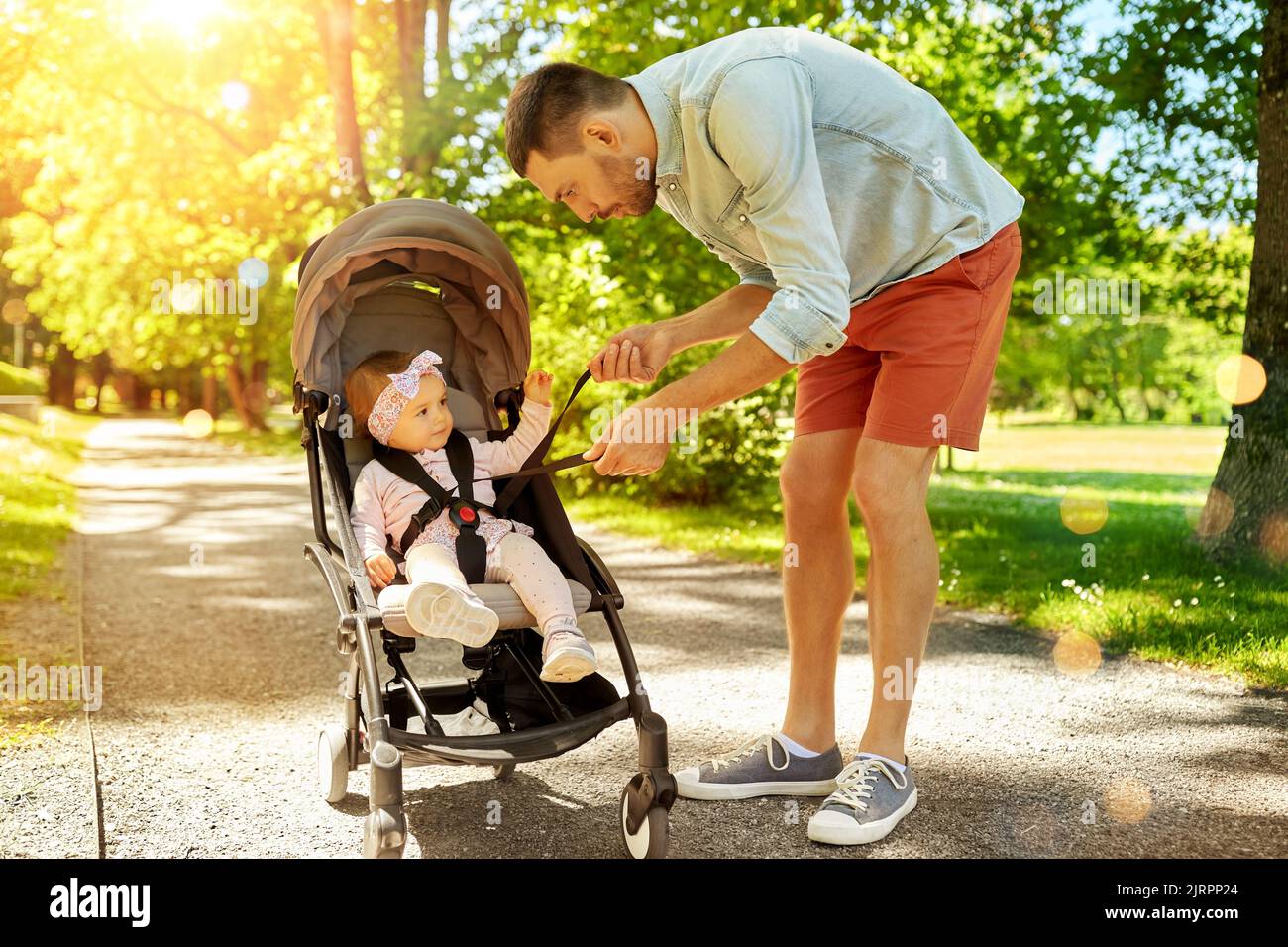 father with child sitting in stroller at park Stock Photo - Alamy