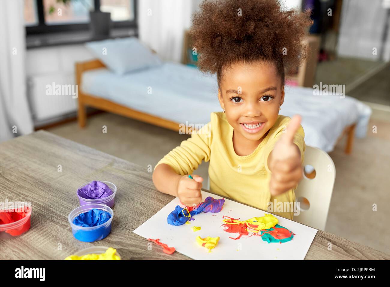 little girl with modeling clay playing at home Stock Photo - Alamy