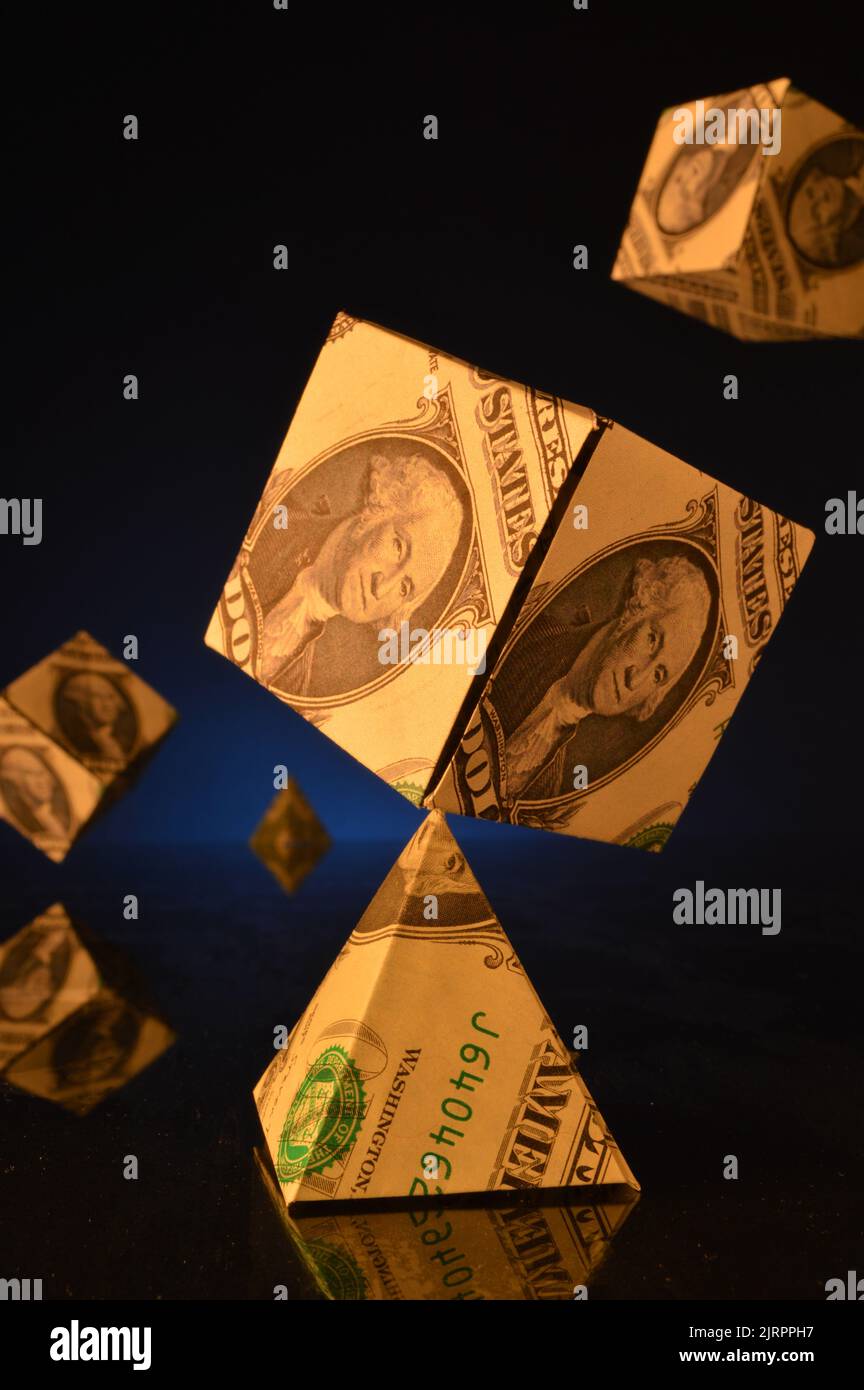 Dollar cube balancing on dollar pyramid Stock Photo - Alamy