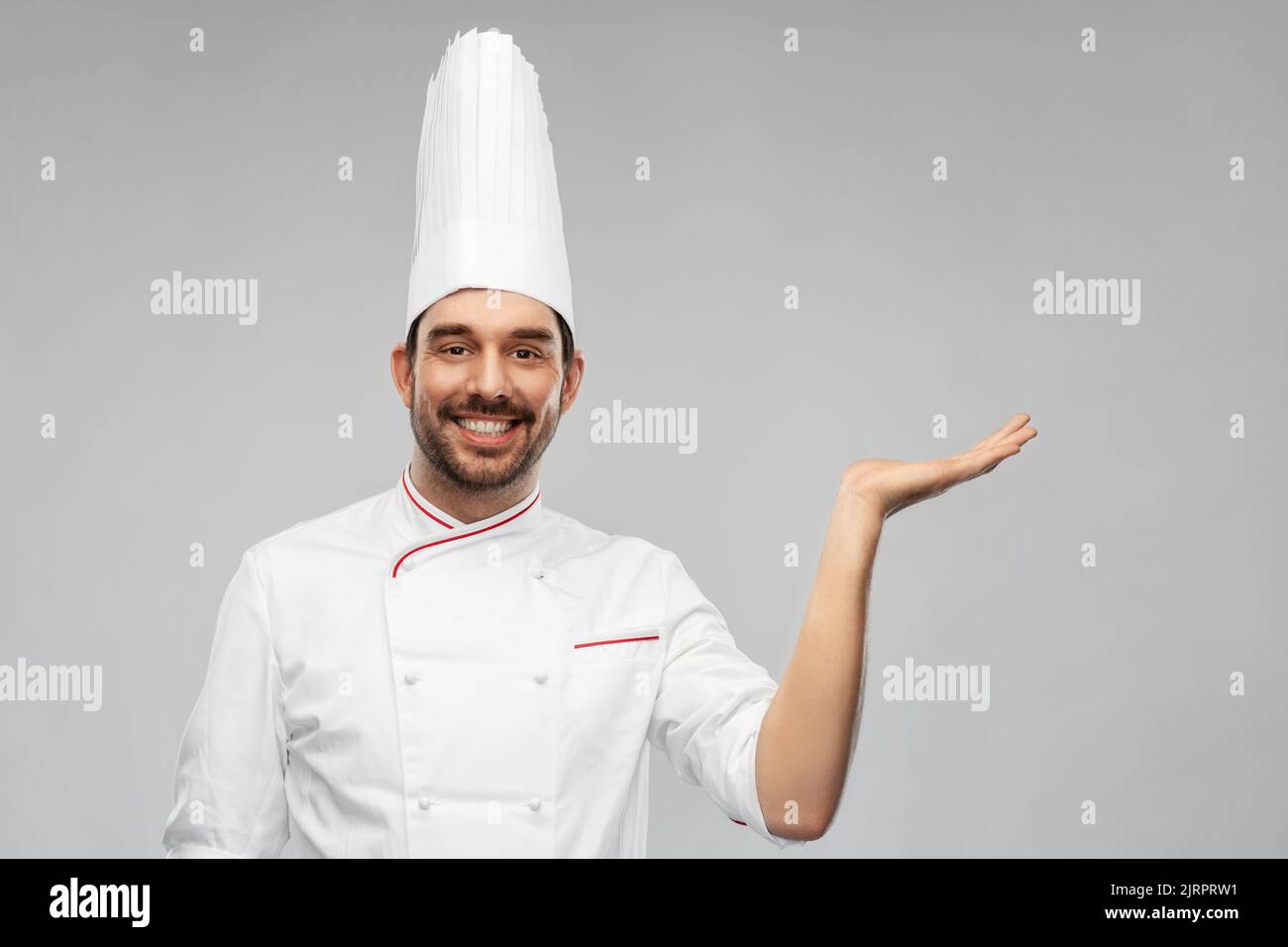 happy smiling male chef holding something on hand Stock Photo - Alamy