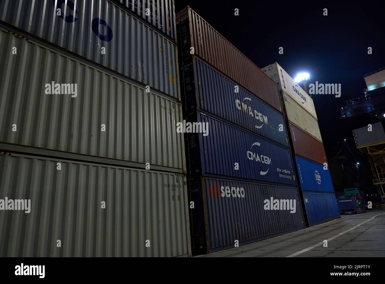 Operation of container terminal at night. Unloading container ship at ...