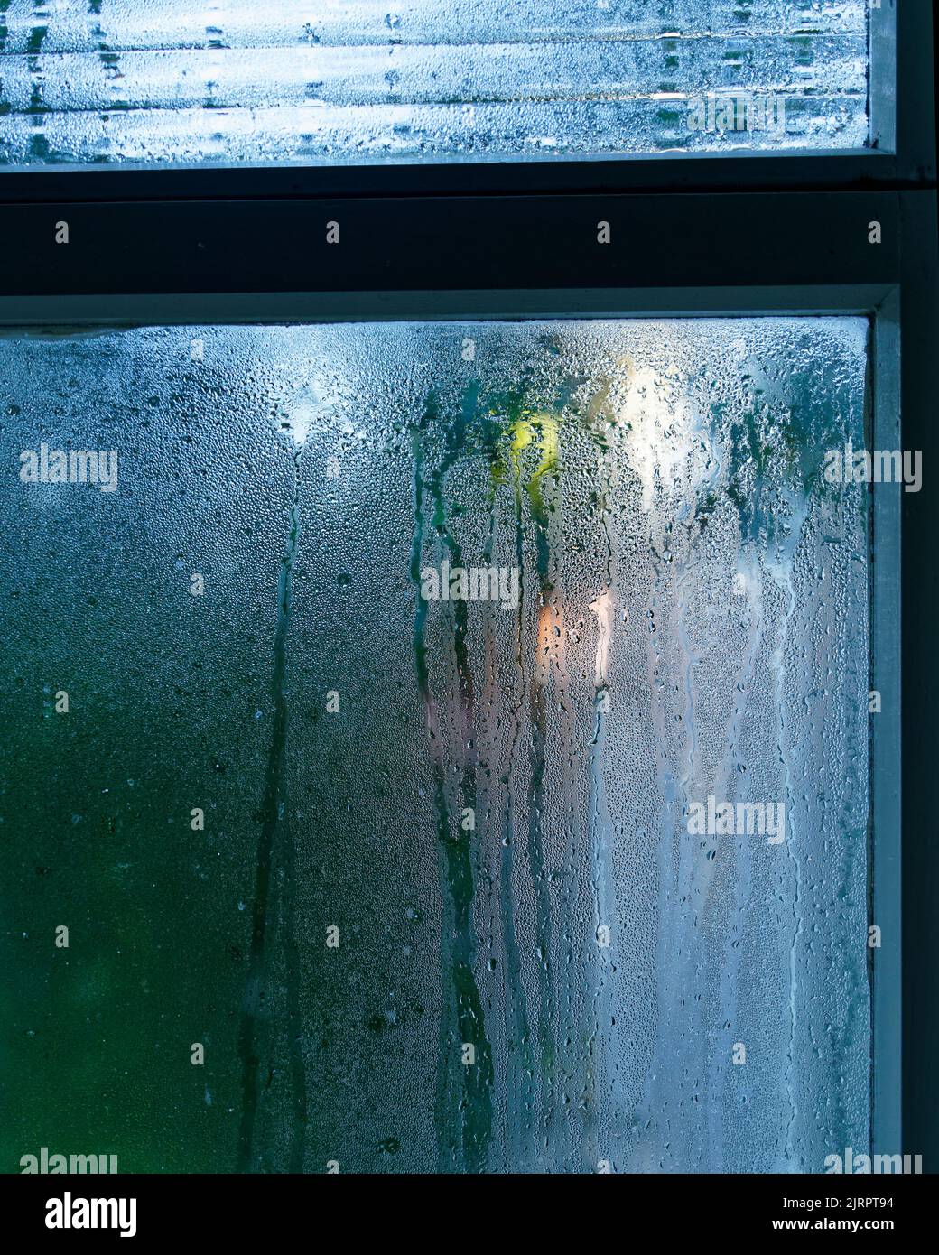 Condensation on the inside of a single glazed window in a cold damp ...