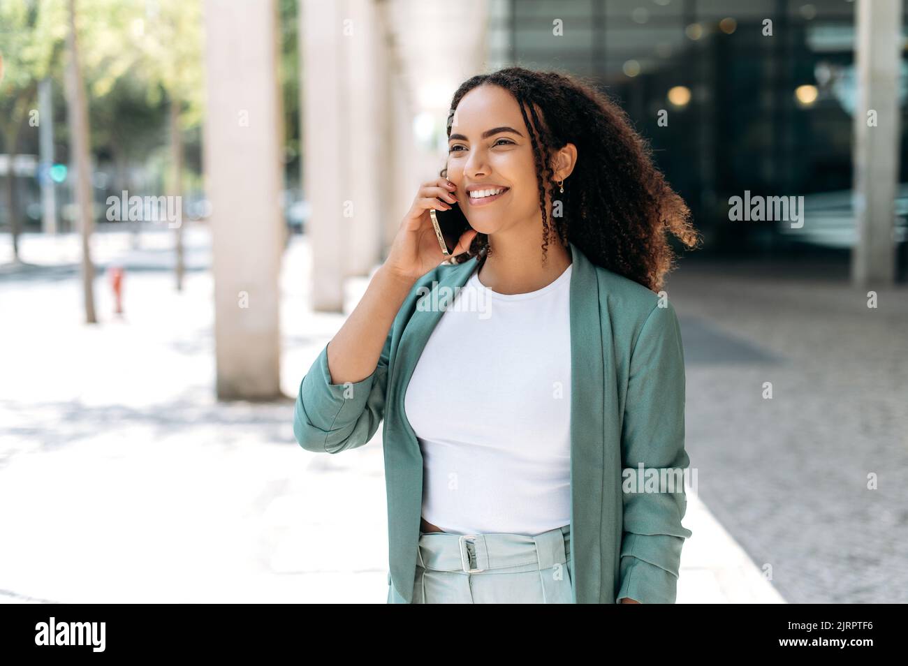Mobile phone conversation. Lovely positive young mixed race curly ...