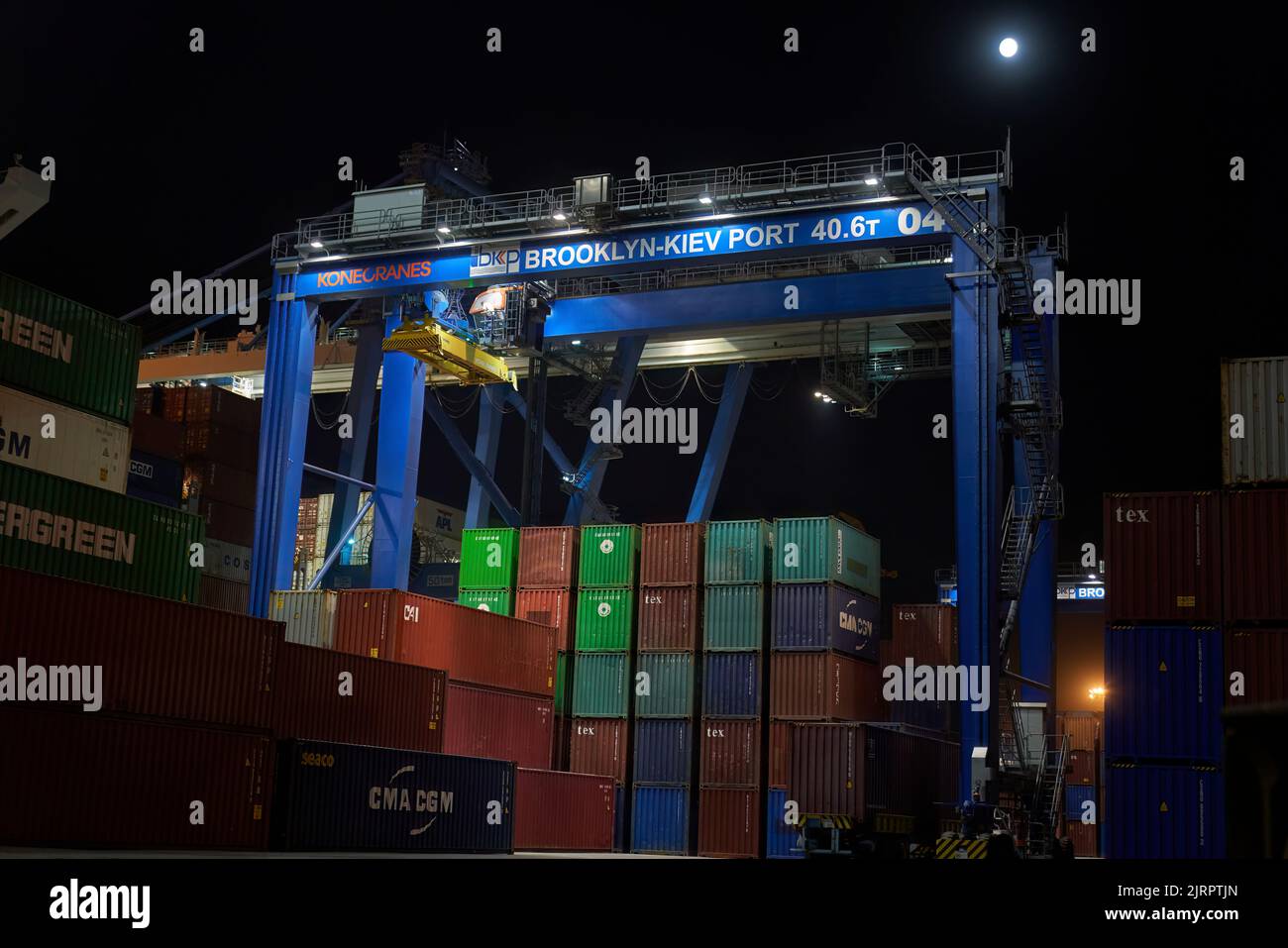 Operation of container terminal at night. Unloading container ship at ...