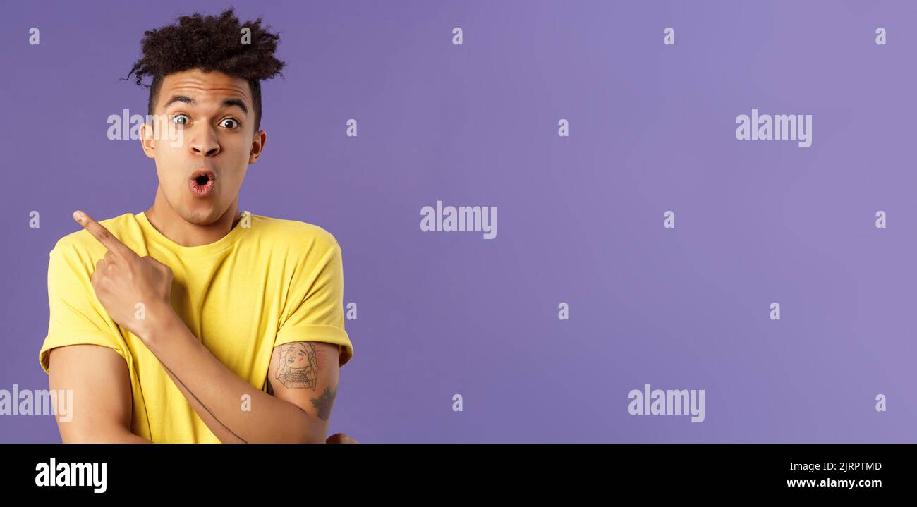 Portrait of surprised, excited young man showing cool new thing ...