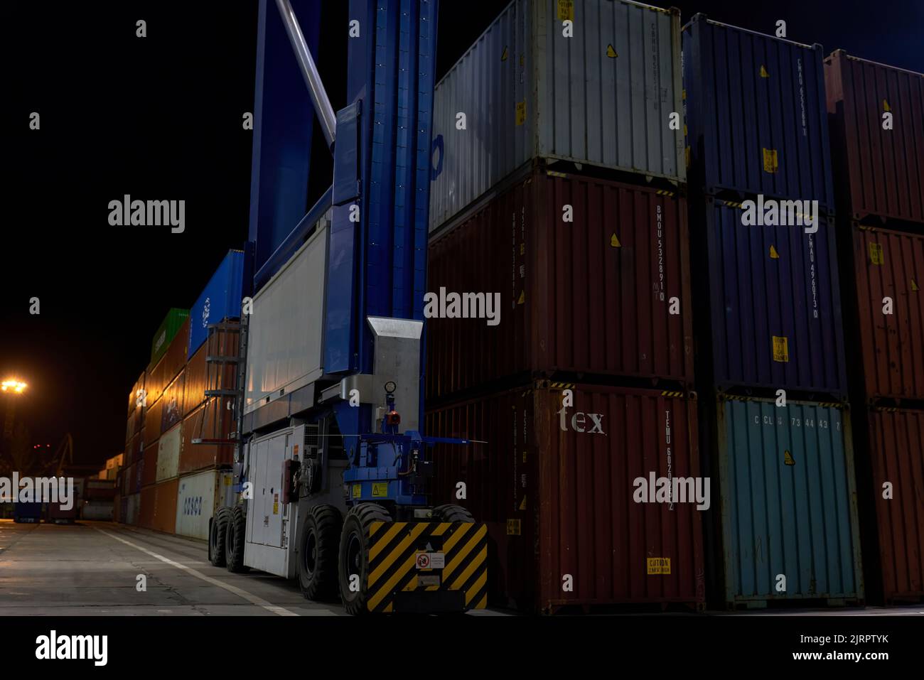 Operation of container terminal at night. Unloading container ship at ...