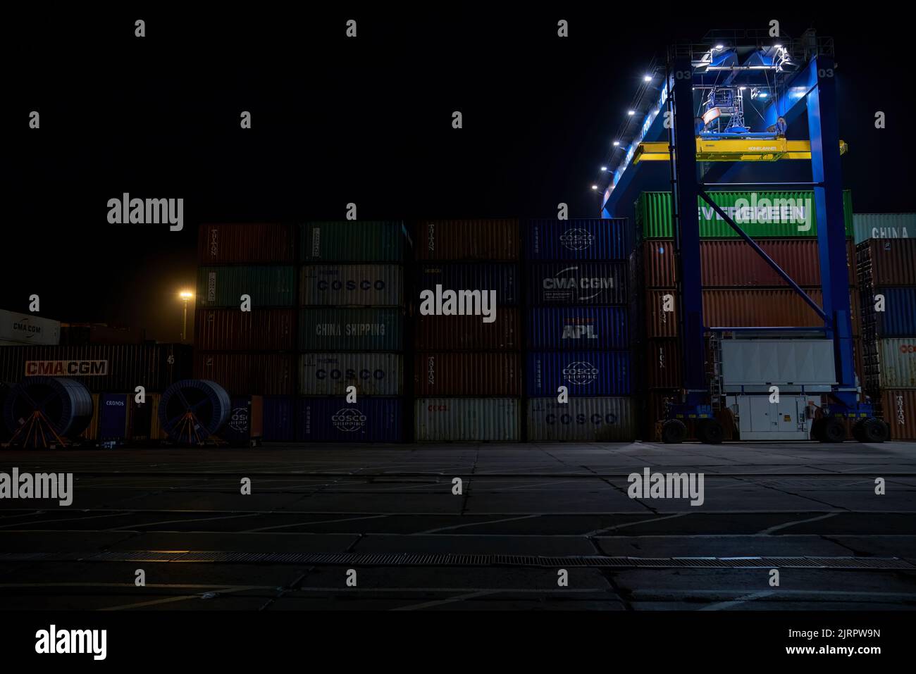 Operation of container terminal at night. Unloading container ship at ...