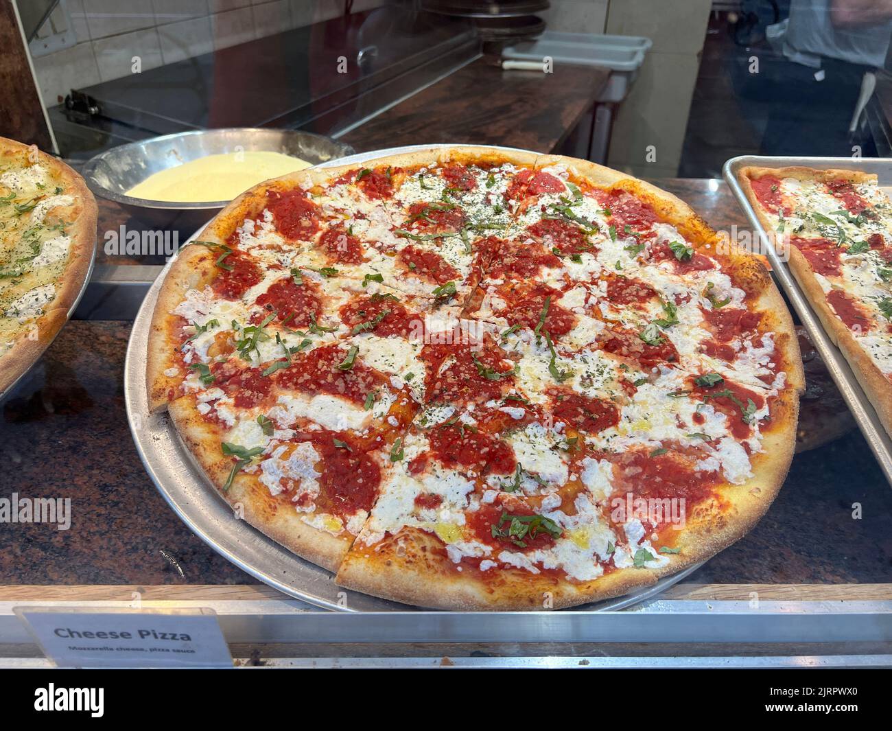 Fresh made pizza displayed in the window at a pizzeria in Manhattan ...