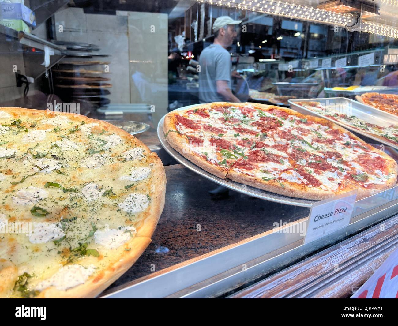 Fresh made pizza displayed in the window at a pizzeria in Manhattan ...