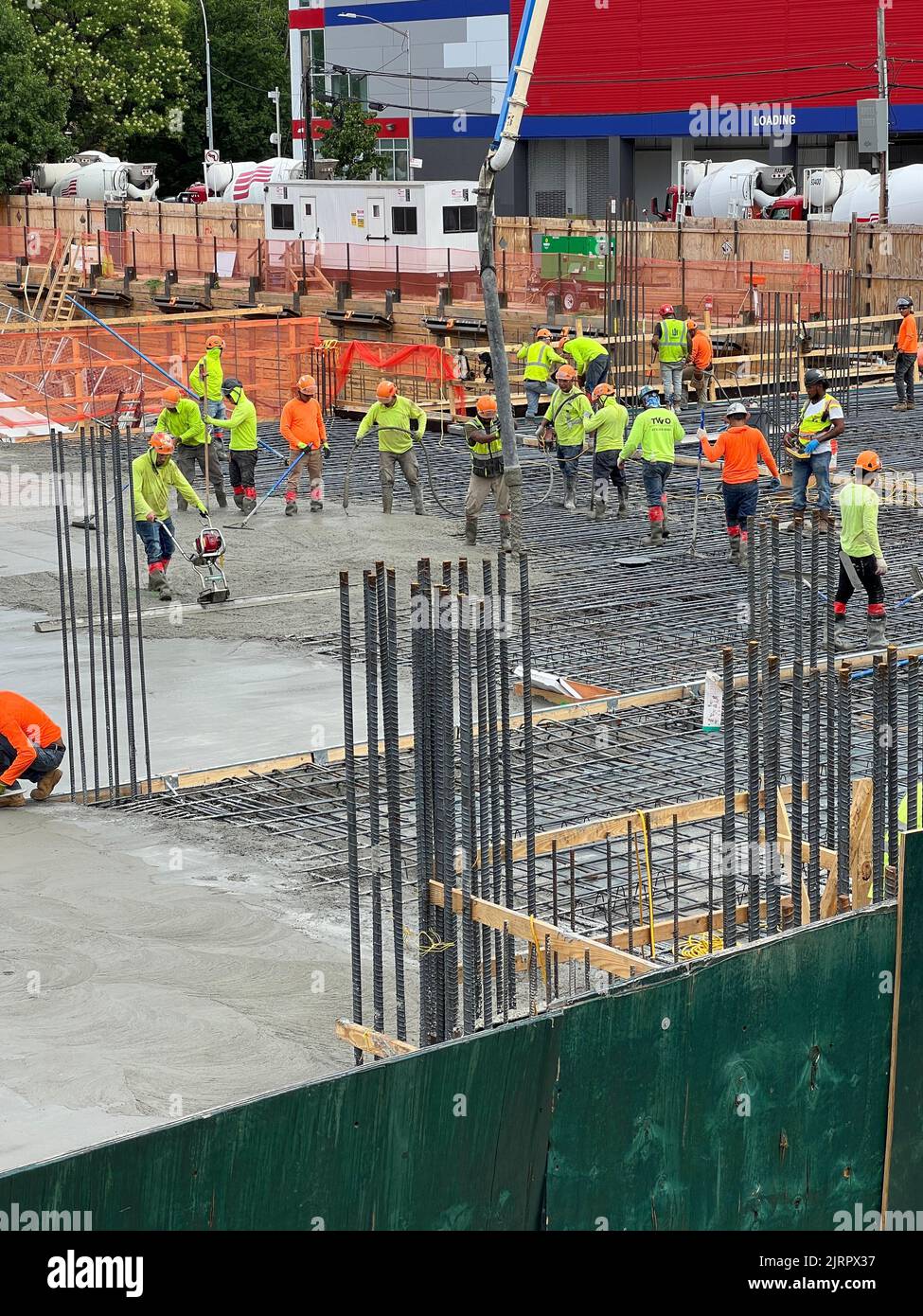 Cement workers putting in a huge cement floor above the basement garage ...