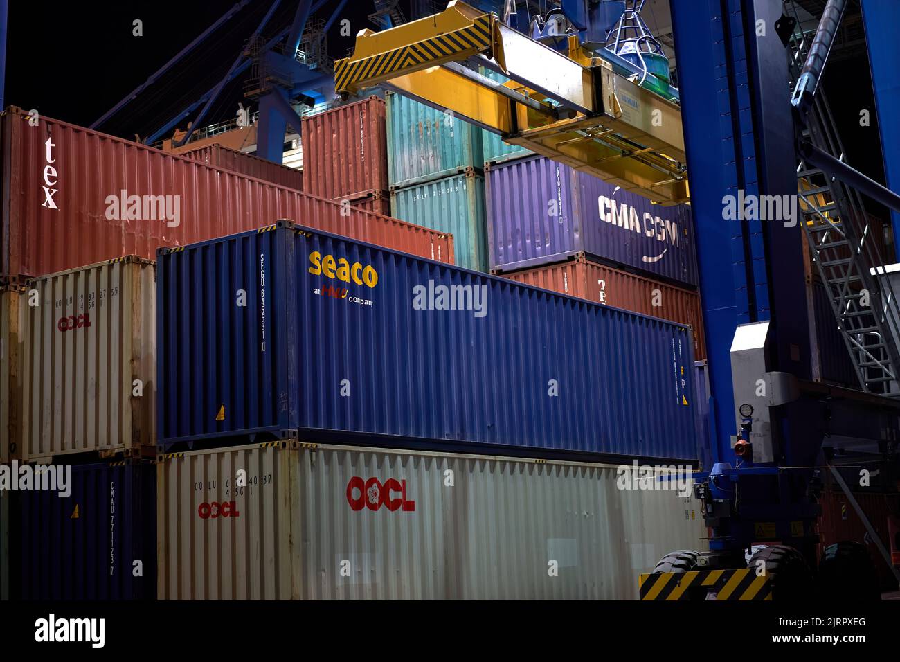 Operation of container terminal at night. Unloading container ship at ...