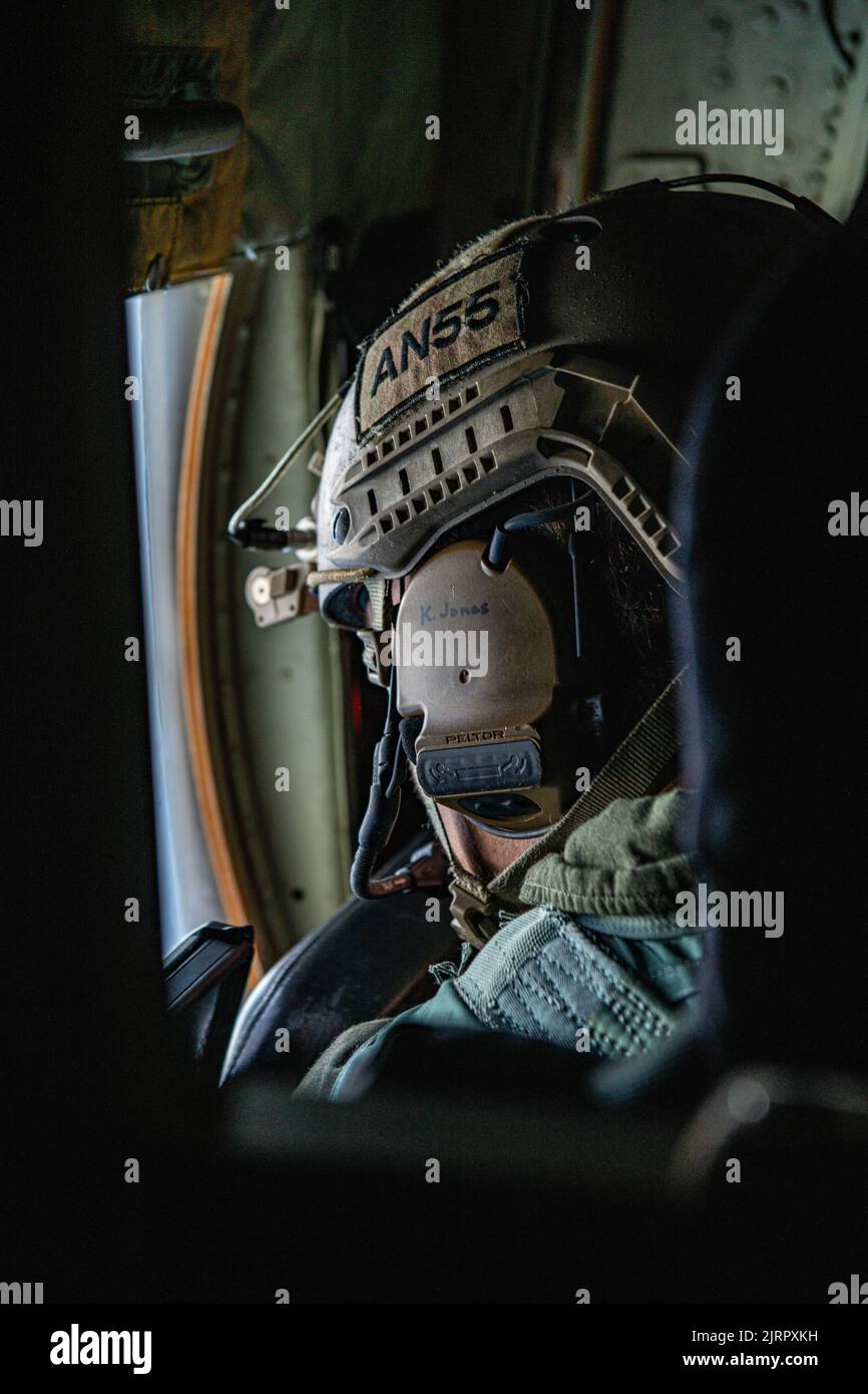 A 1st Special Operations Squadron loadmaster looks out the window of an MC-130J Commando II ...