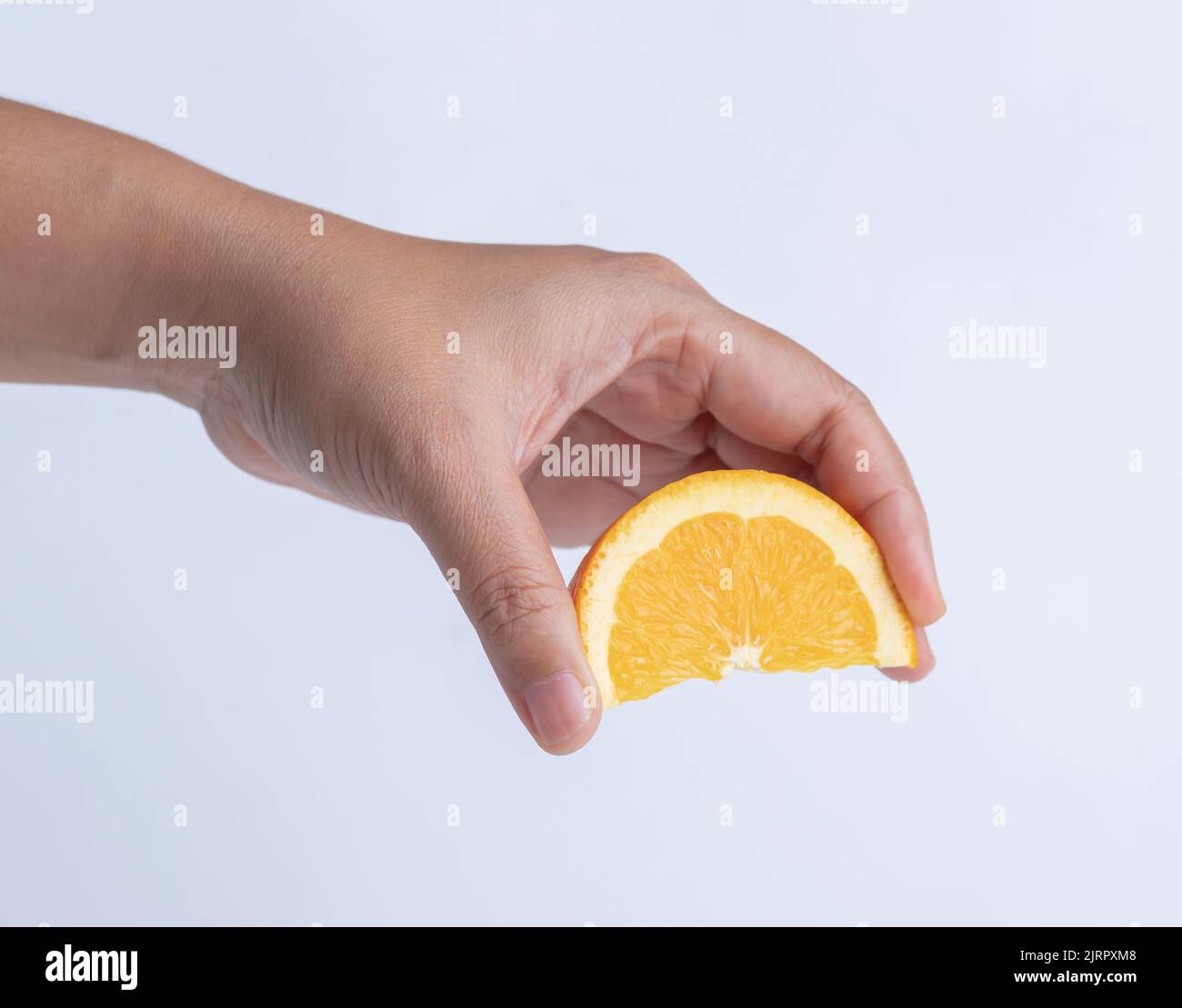 hand holding fresh raw citrus. hand squeezing orange fruit sliced on ...