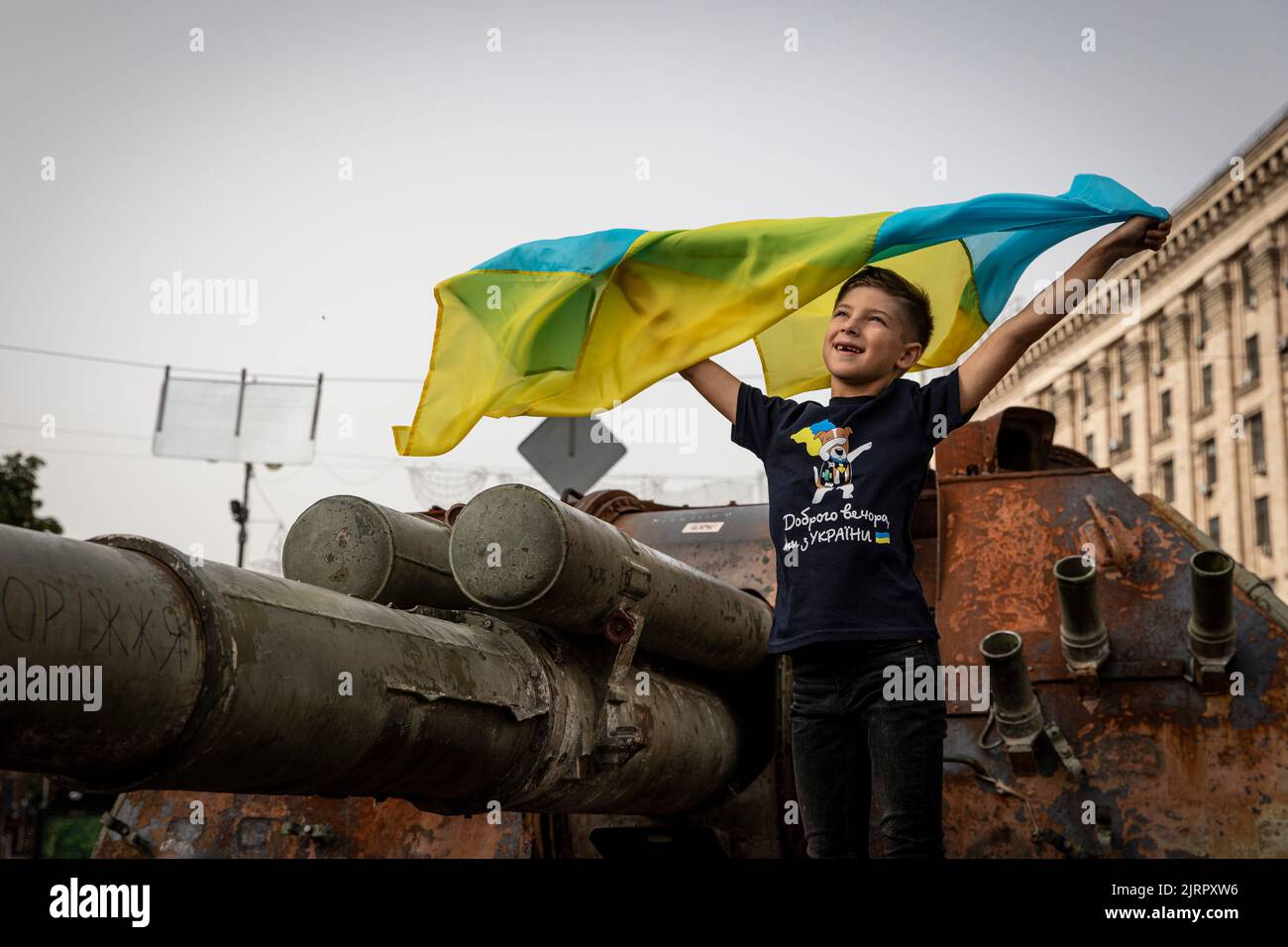 Boy Dima waves his Ukrainian flag as he stands on the wreckage of ...