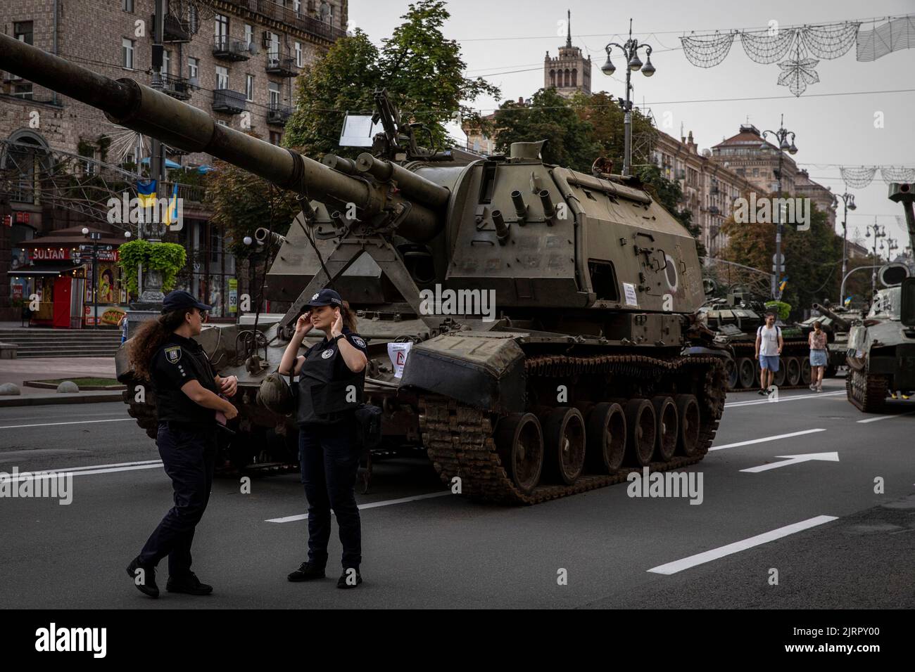 Two police officers stand in front of a display of destroyed Russian ...