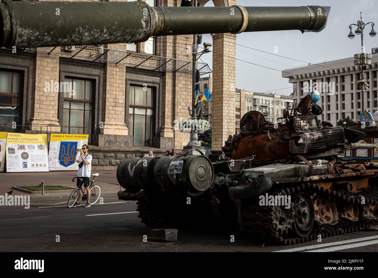 A man stops by with his bicycle and takes a photo of the destroyed ...