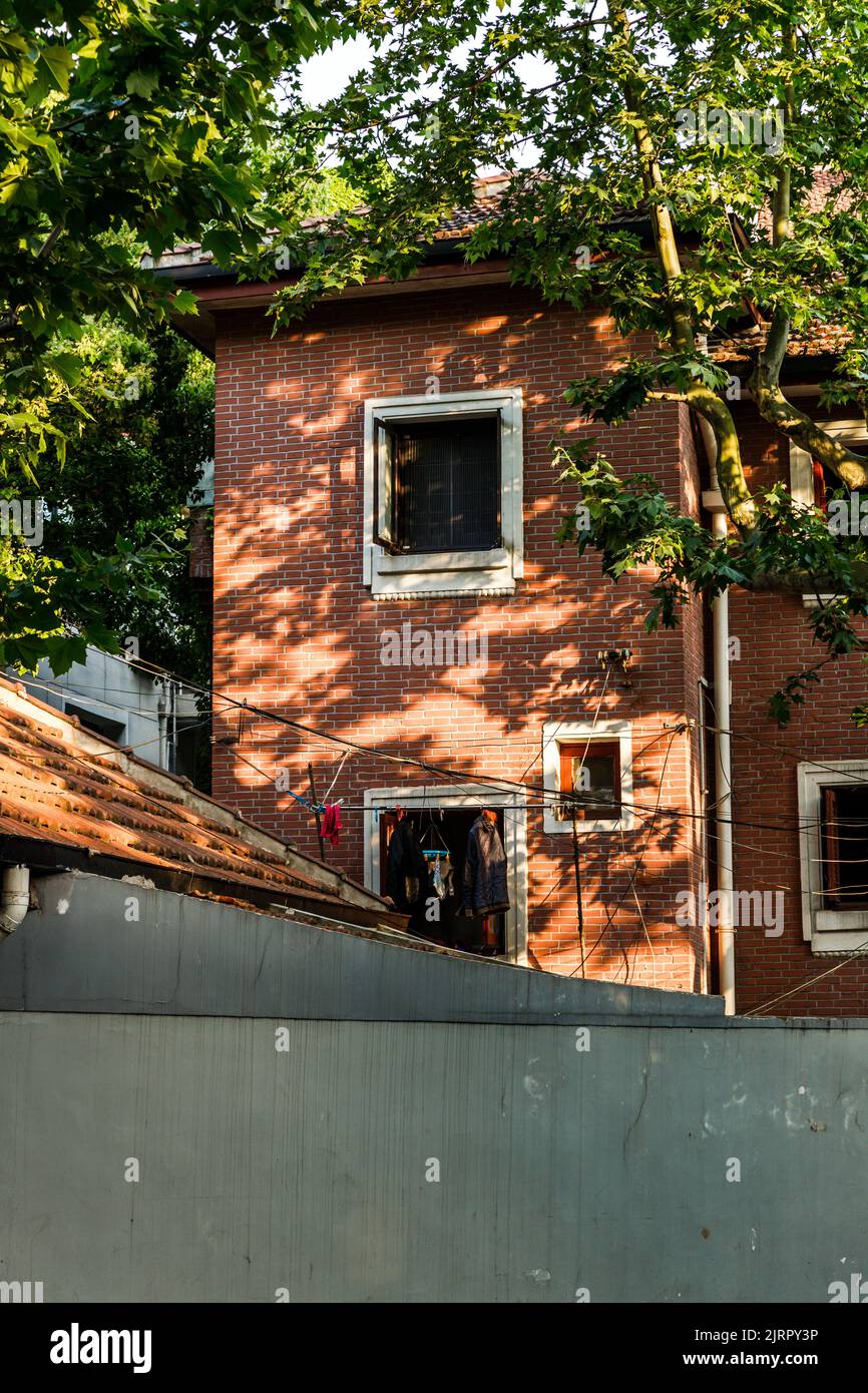 A vertical shot of a typical brick house in Shanghai with greenery ...