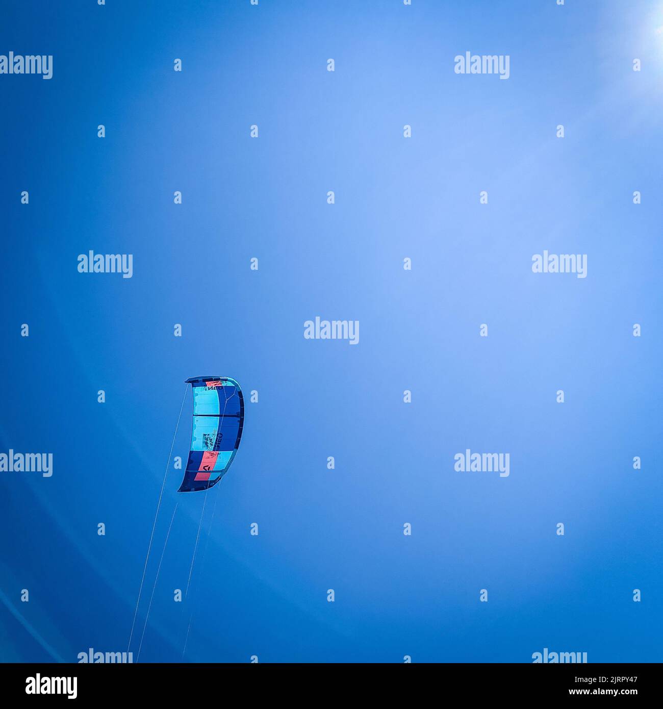 Wind kite flying under blue skies at the beach Stock Photo - Alamy