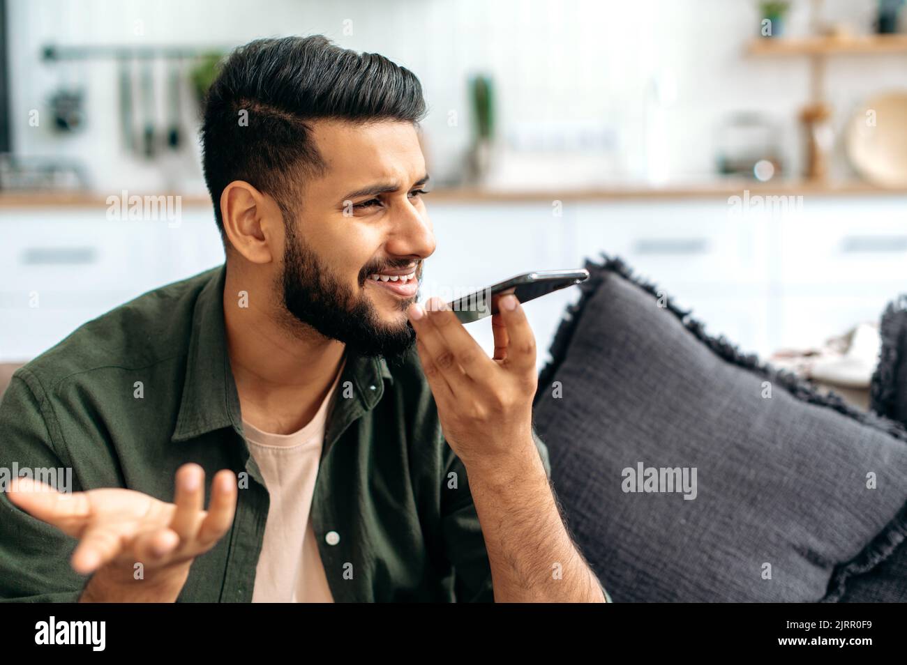 Speakerphone conversation. Positive indian or arabian young man in ...