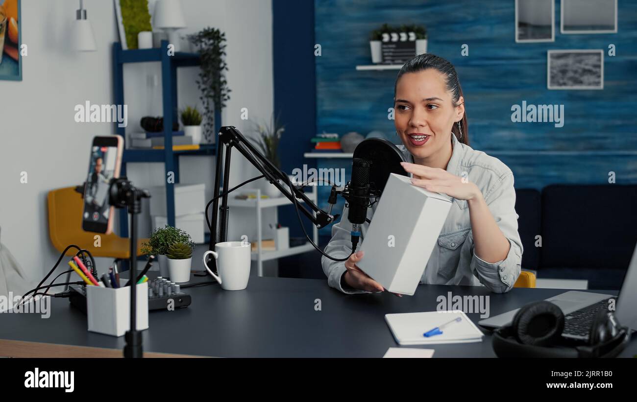 Popular tech enthusiast doing unboxing review video in living room ...