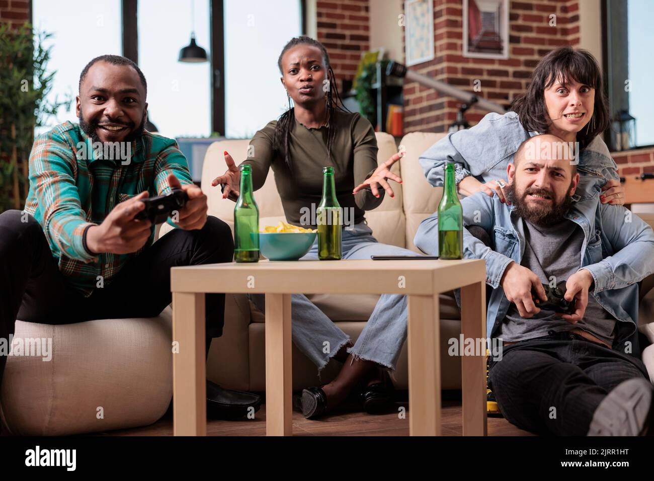 Multiethnic group of friends playing video games together on console ...