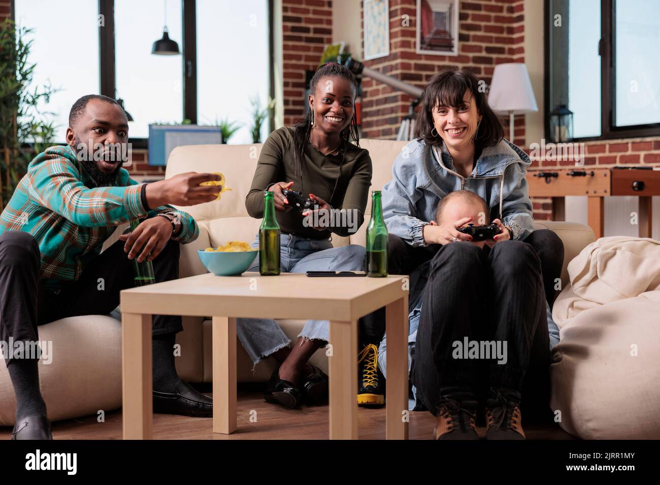 Multiethnic group of men and women playing video games on tv console ...