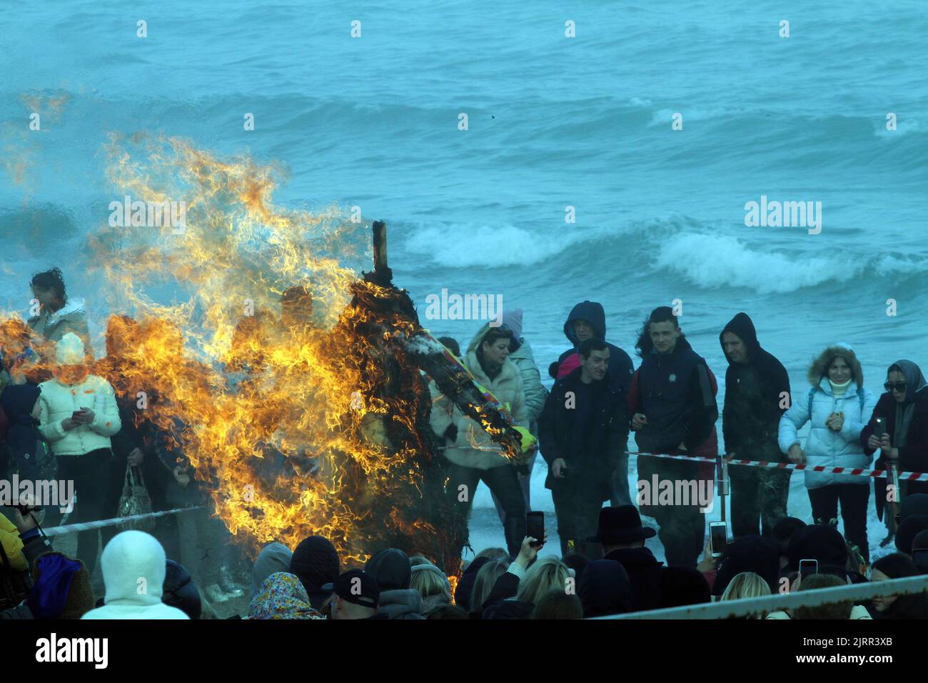 People are seen taking pictures of Winter's burning scarecrow ...