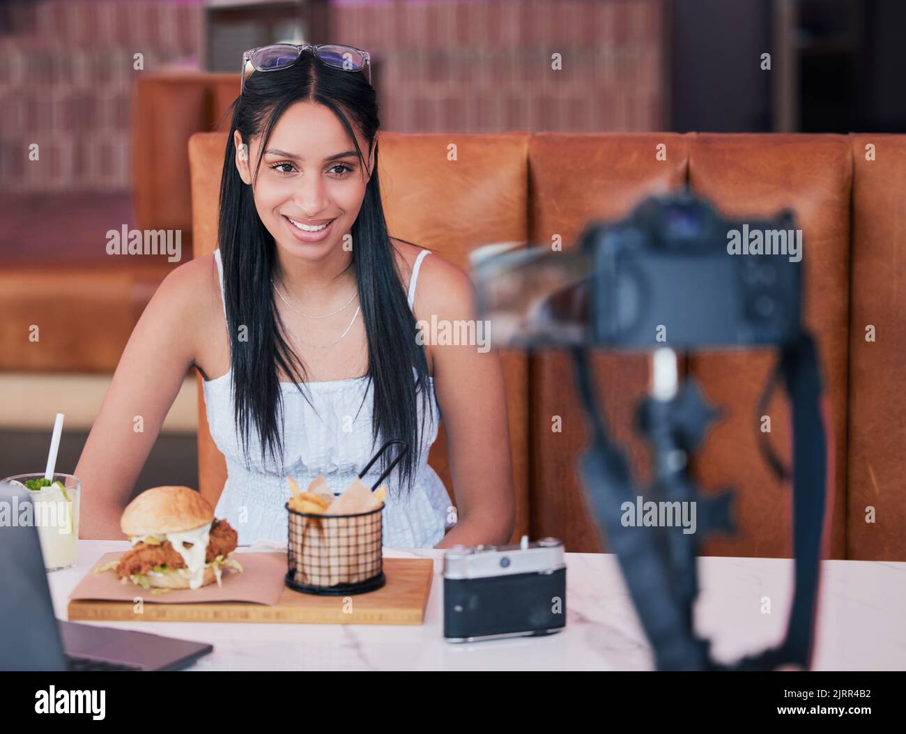 Food influencer, internet speaker at restaurant with camera and ...