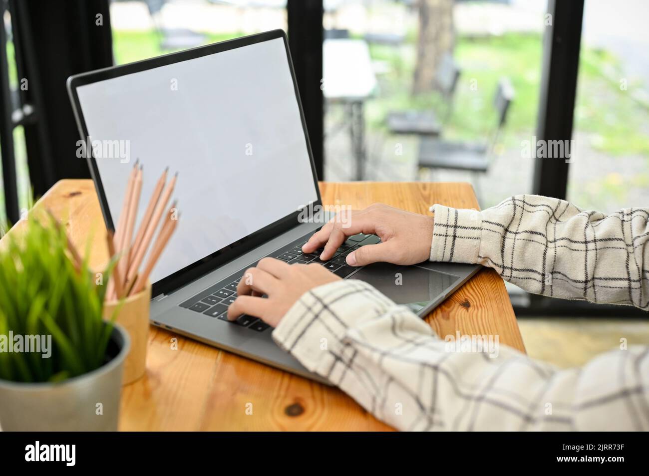 A man remote working in the coffee shop, using notebook laptop computer ...